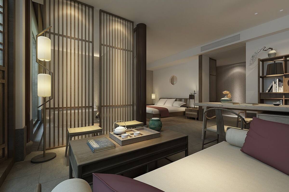 Quarto de hotel moderno com cama, mesas de cabeceira, escrivaninha e estante de livros.