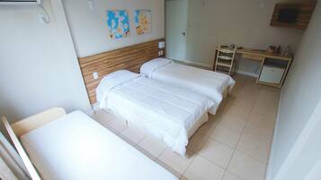 Quarto com duas camas, uma escrivaninha, uma cadeira e uma porta.