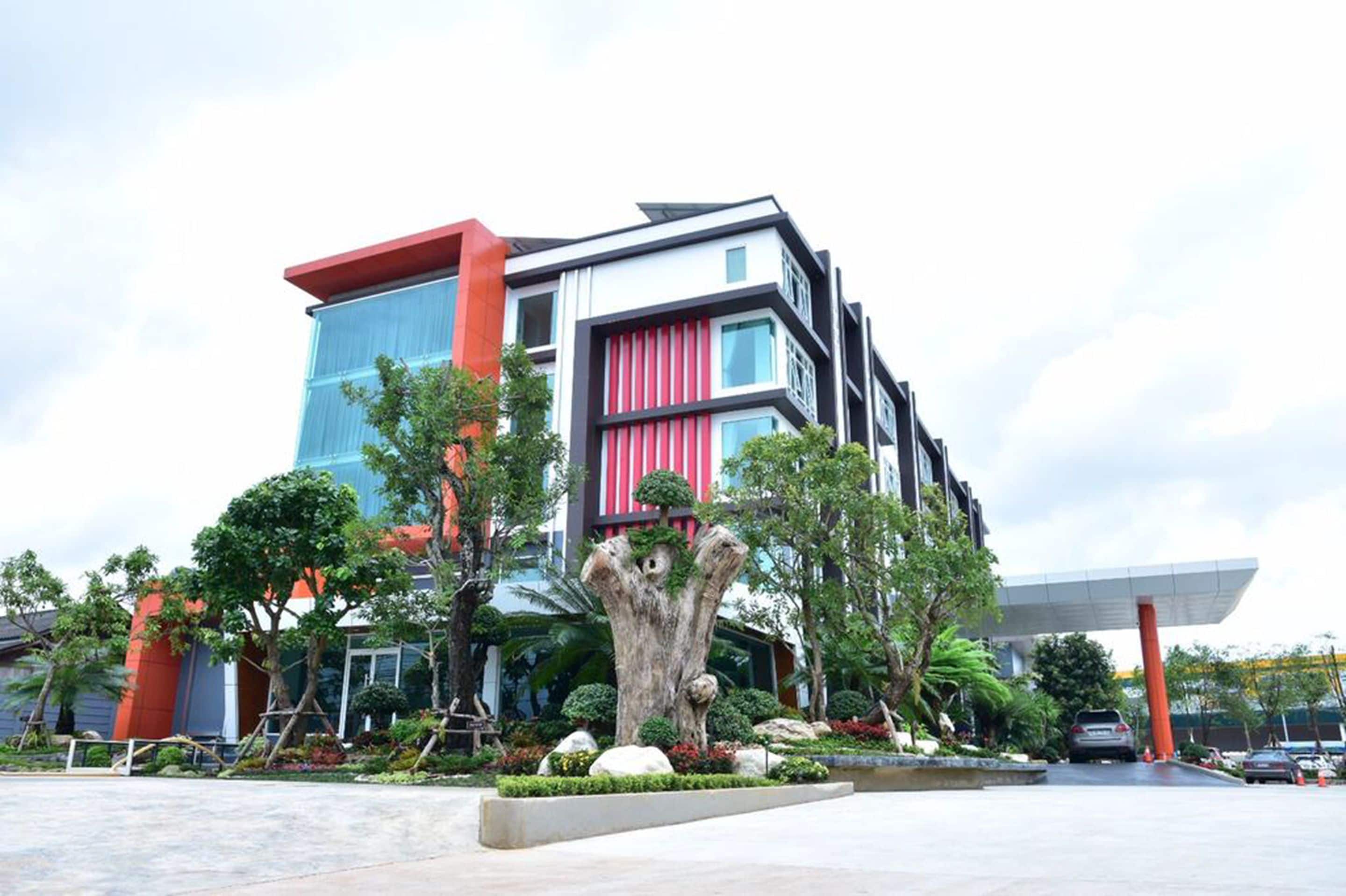 Um edifício moderno com estrutura em vários andares, grandes janelas e fachada proeminente em vermelho e preto.
