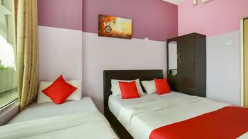 Quarto de hotel com duas camas, um espelho grande e um quadro na parede.