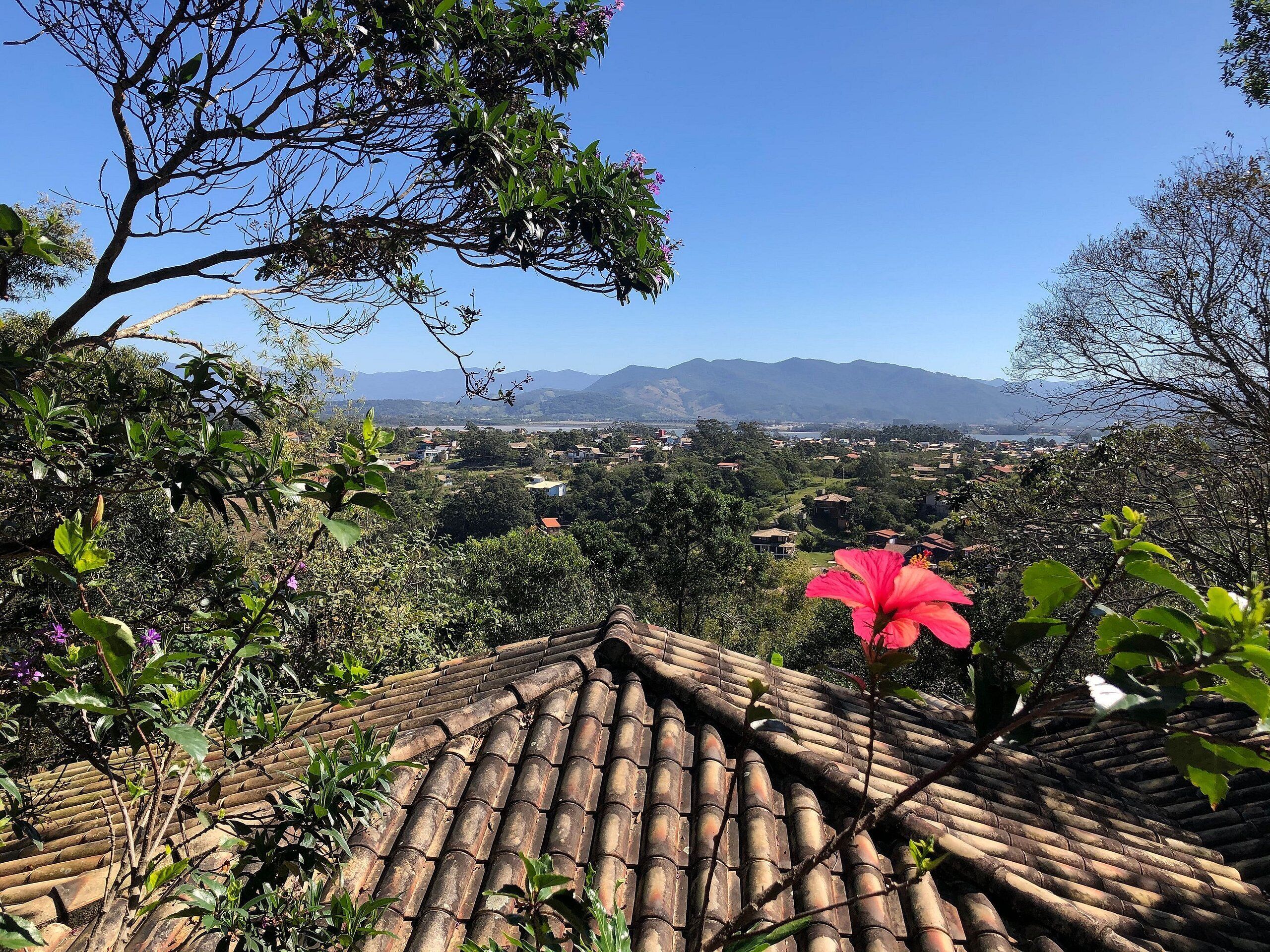 Um telhado tradicional de azulejos com vista para uma cidade e montanhas ao longe.