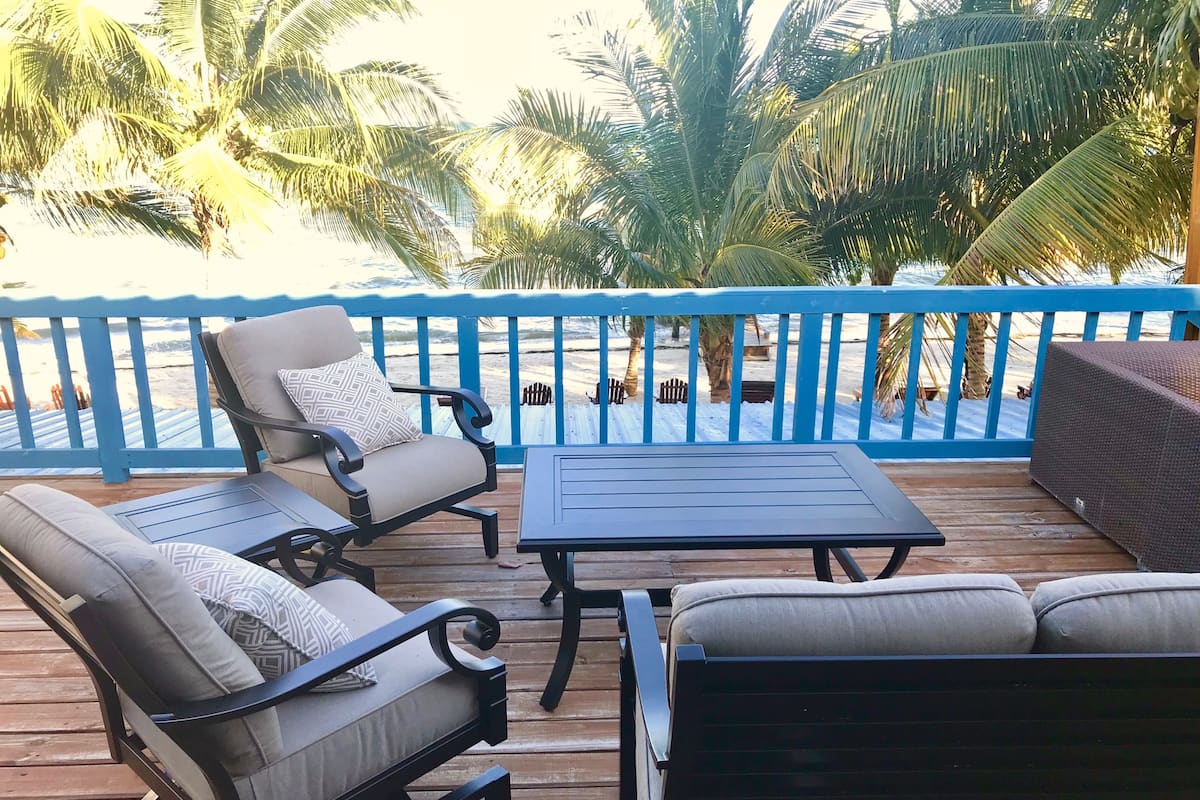 Um terraço com mobiliário de exterior, incluindo um sofá, cadeiras e uma mesa.