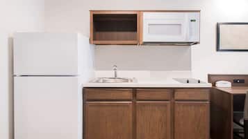 Um frigorífico/congelador grande, um micro-ondas, uma placa de cozinha