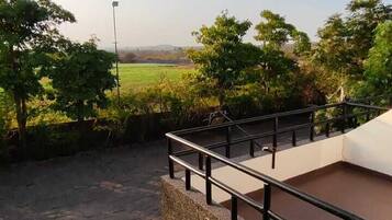 Varanda com vista para uma paisagem verde e um carro estacionado.