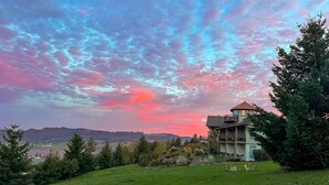 Uma casa com varanda e vista para um vale.