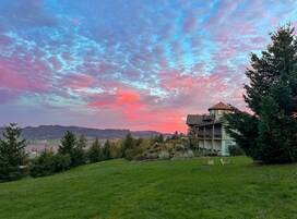 Uma casa com varanda e vista para um vale.