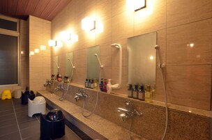 Uma casa de banho moderna com várias bacias, espelhos e secadores de mãos.