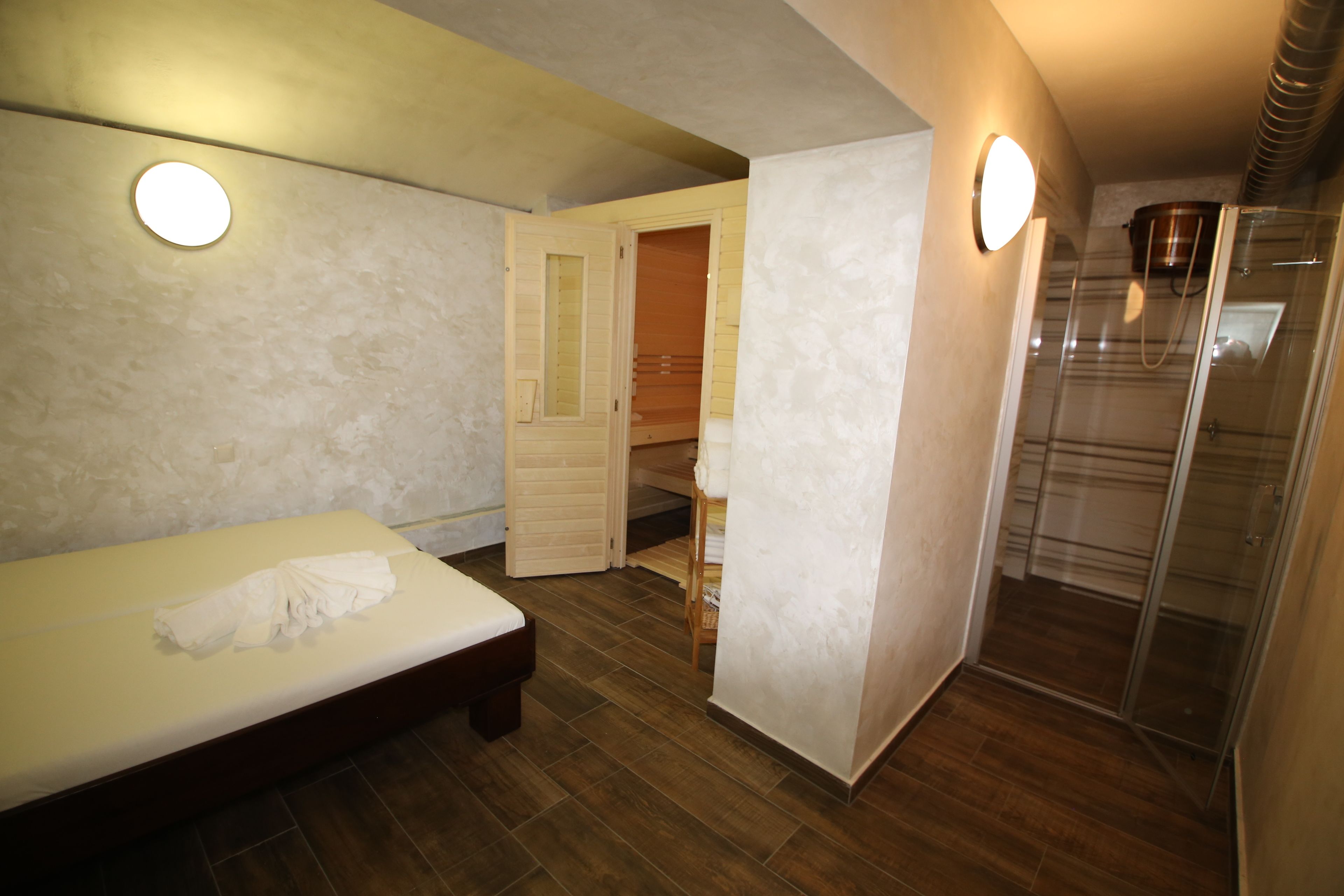 Quarto de hotel com cama, closet espaçoso e área de chuveiro.