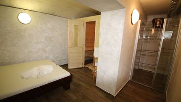 Quarto de hotel com cama, closet espaçoso e área de chuveiro.