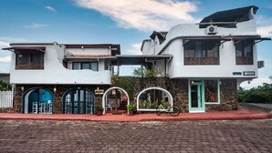 Um edifício de dois andares com fachada de pedra, telhado vermelho e uma bicicleta estacionada na frente.