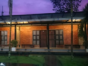 Um edifício moderno com fachada de tijolos, janelas grandes e uma varanda coberta.