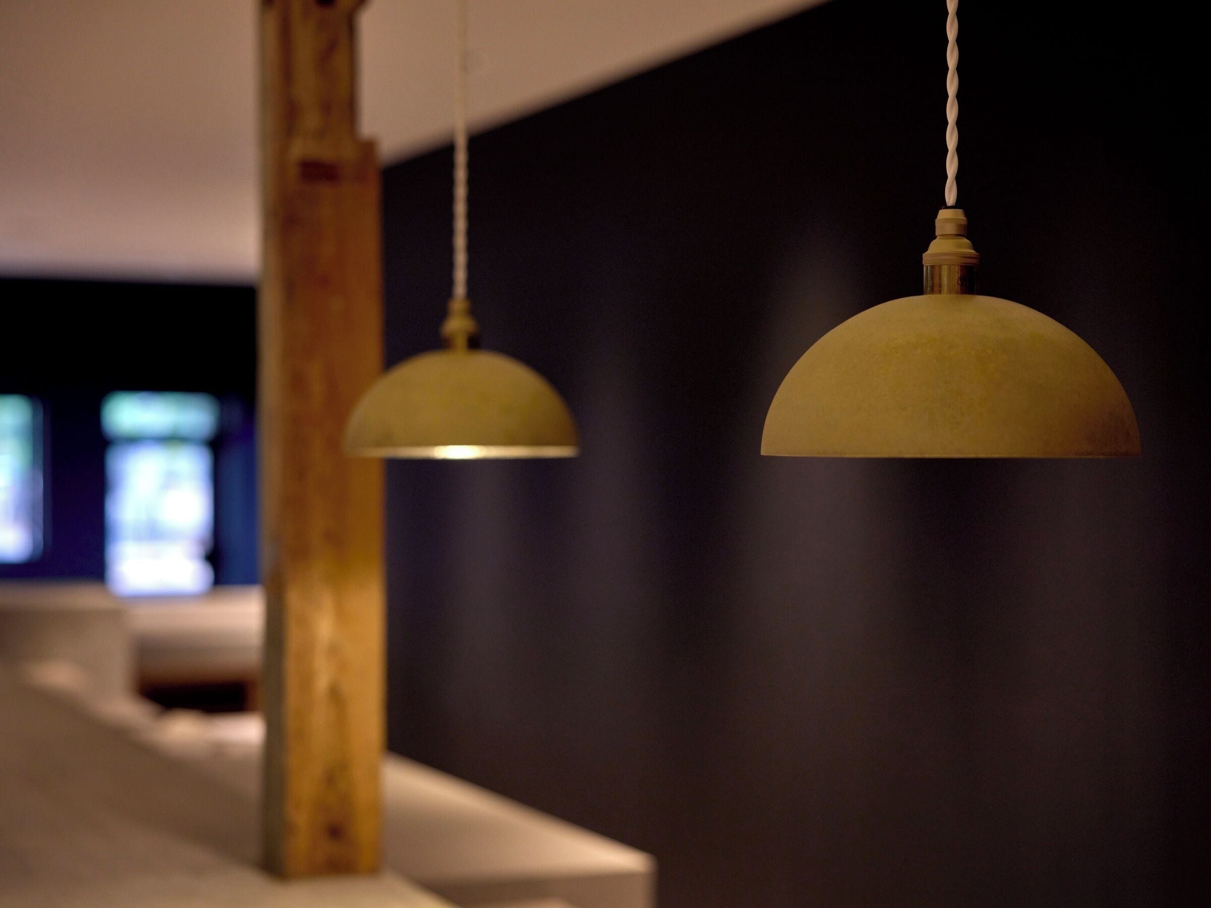 Um interior moderno com duas luminárias pendentes e um pilar de madeira.