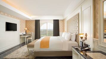 Quarto de hotel com cama grande, escrivaninha, televisão de tela plana e vista para a cidade.