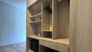 Um espaço de armazenamento moderno com várias prateleiras e compartimentos, incluindo uma área para pendurar objetos.