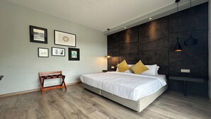 Quarto moderno com cama, luminárias fixadas na parede e quadros emoldurados.