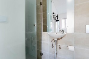 Estúdio, 2 camas individuais, kitchenette, vista para o pátio | Casa de banho | Um polibã, artigos de higiene pessoal grátis, um secador de cabelo 