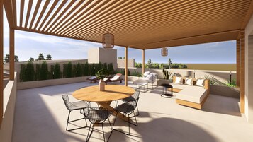 Terraço no telhado com pérgola de madeira, mesa redonda com cadeiras, um sofá e uma mesinha com abajur.