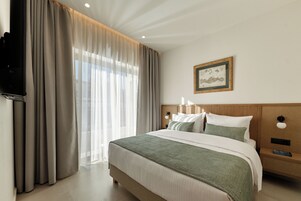 Quarto de hotel com uma cama grande, televisão fixada na parede e um mapa emoldurado.