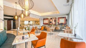 Um lobby de hotel moderno com área de bar, assentos e uma grande janela que oferece luz natural.