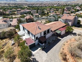 Zona residencial com casas de vários tamanhos e andares, algumas com telhados de telha vermelha e outras com toldos verdes.