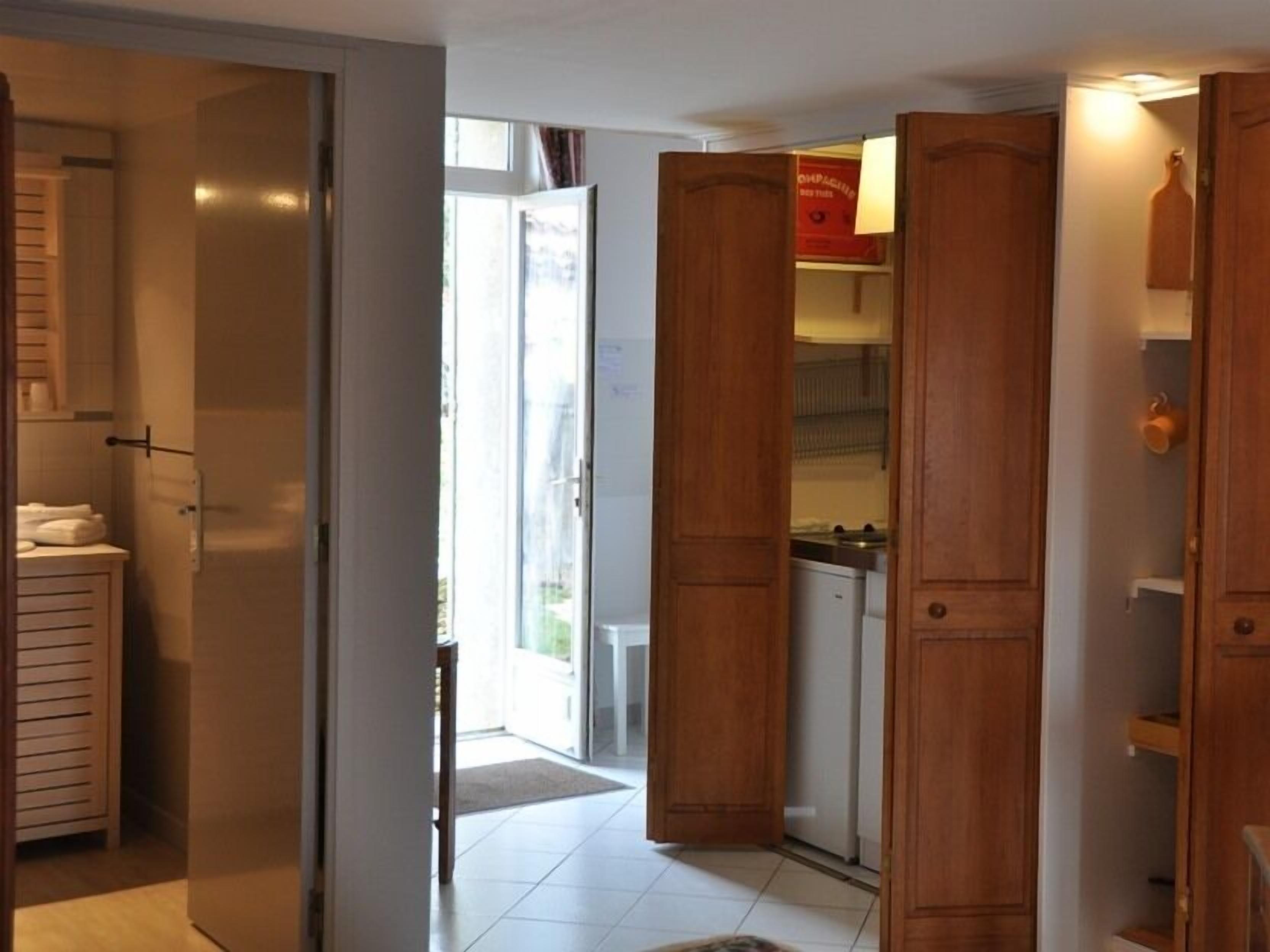 Quarto de hotel com banheiro, cozinha compacta e vista para o exterior.