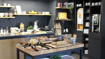 Um buffet de café da manhã com diversos pães, bolos e bebidas.