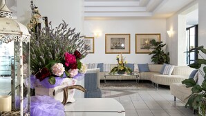 Uma sala de estar moderna com sofá, mesa de centro e um vaso decorativo com flores.