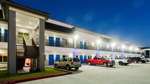 Um motel com vários andares e estacionamento.