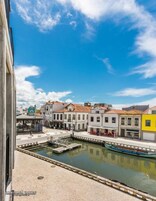 Um canal com edifícios ao longo da água, um cais e uma passarela para pedestres.