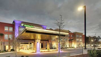 Um Holiday Inn Express & Suites com entrada coberta e estacionamento.