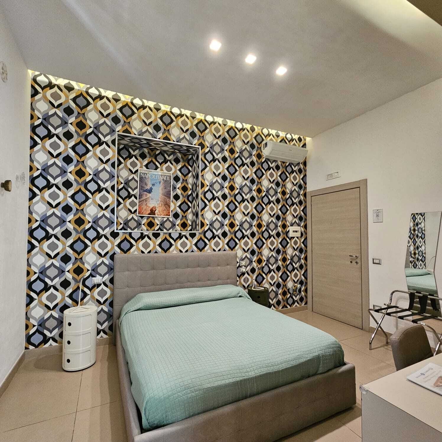 Quarto com parede estampada, cama, mesa de cabeceira e guarda-roupa.