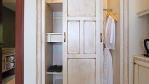 Guarda-roupa branco com cabides para roupas e um prateleira com sapatos.