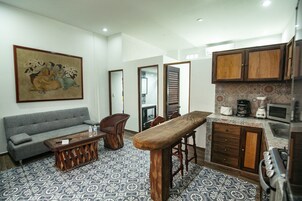 Cozinha moderna com área de jantar, sofá e máquina de café.
