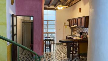 Cozinha com piso de azulejos, armários de madeira, fogão a gás e janela.