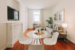 Suite, 1 quarto, kitchenette | Sala de estar | TV de ecrã plano, brinquedos, livros, impressoras 