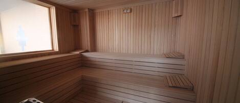 Uma sauna com bancos de madeira e uma janela.