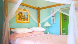Quarto com cama, mesa de cabeceira e quadro na parede.