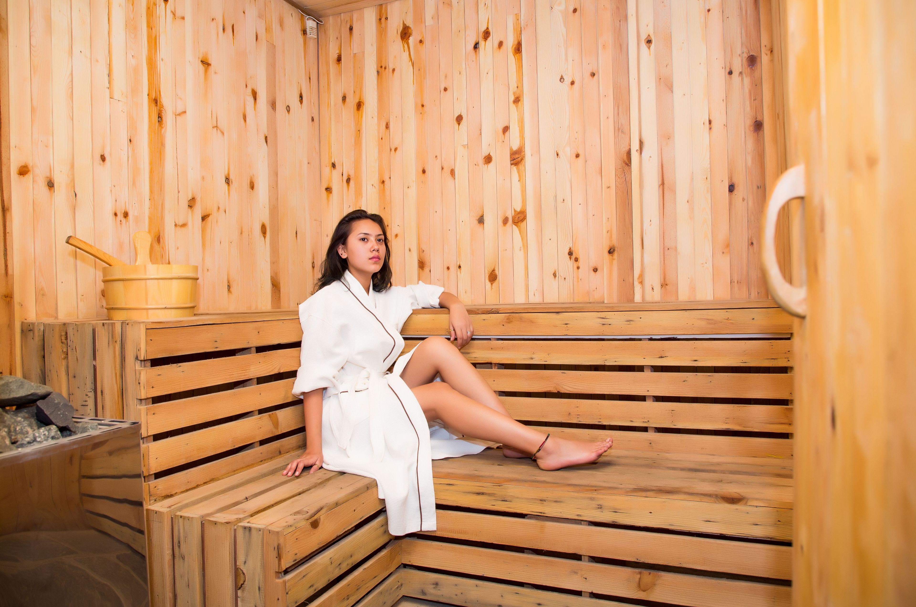 Uma sauna de madeira com bancos e um balde.
