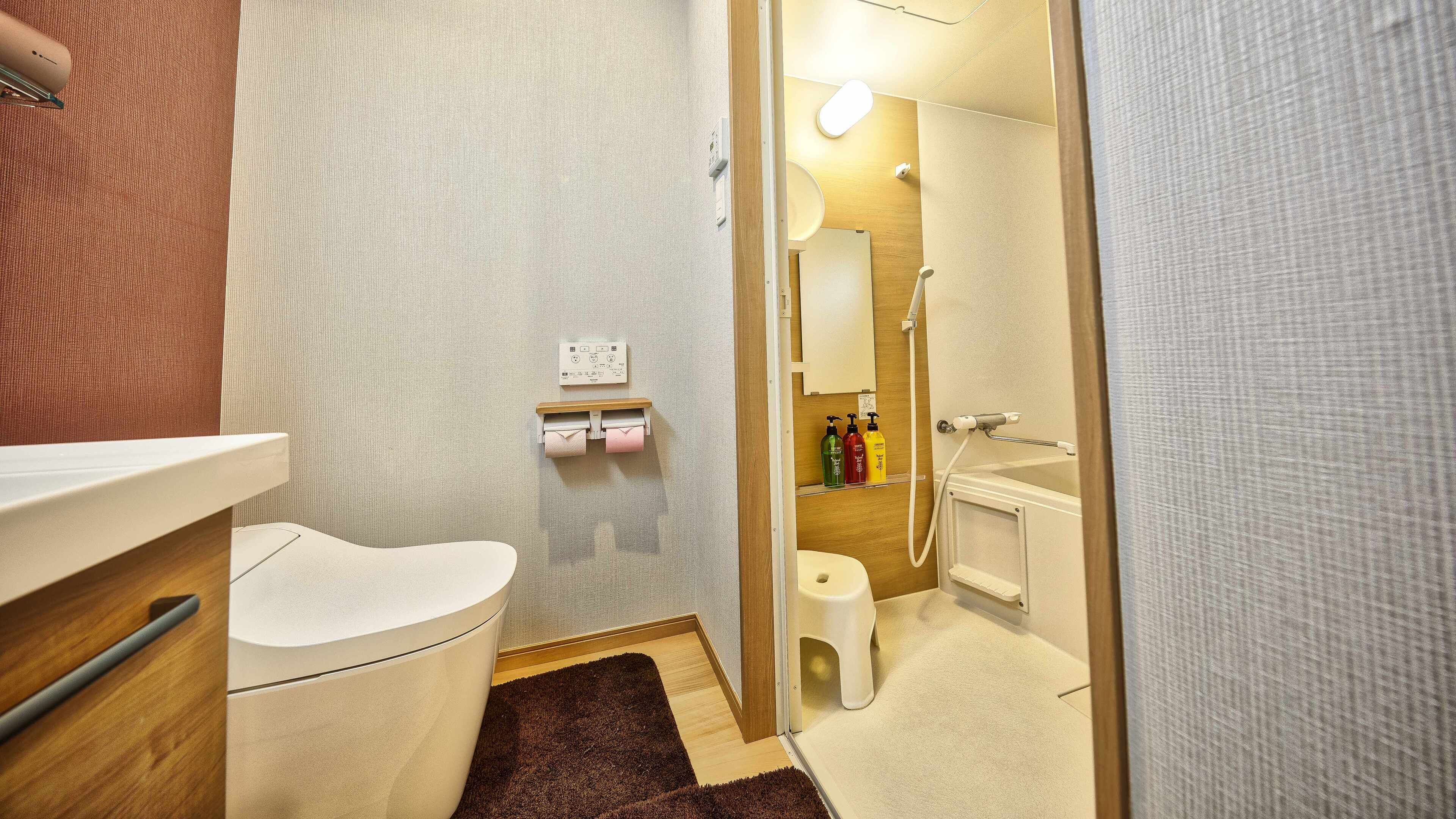Casa de banho compacta com sanita, uma pequena lavatório e área de duche.