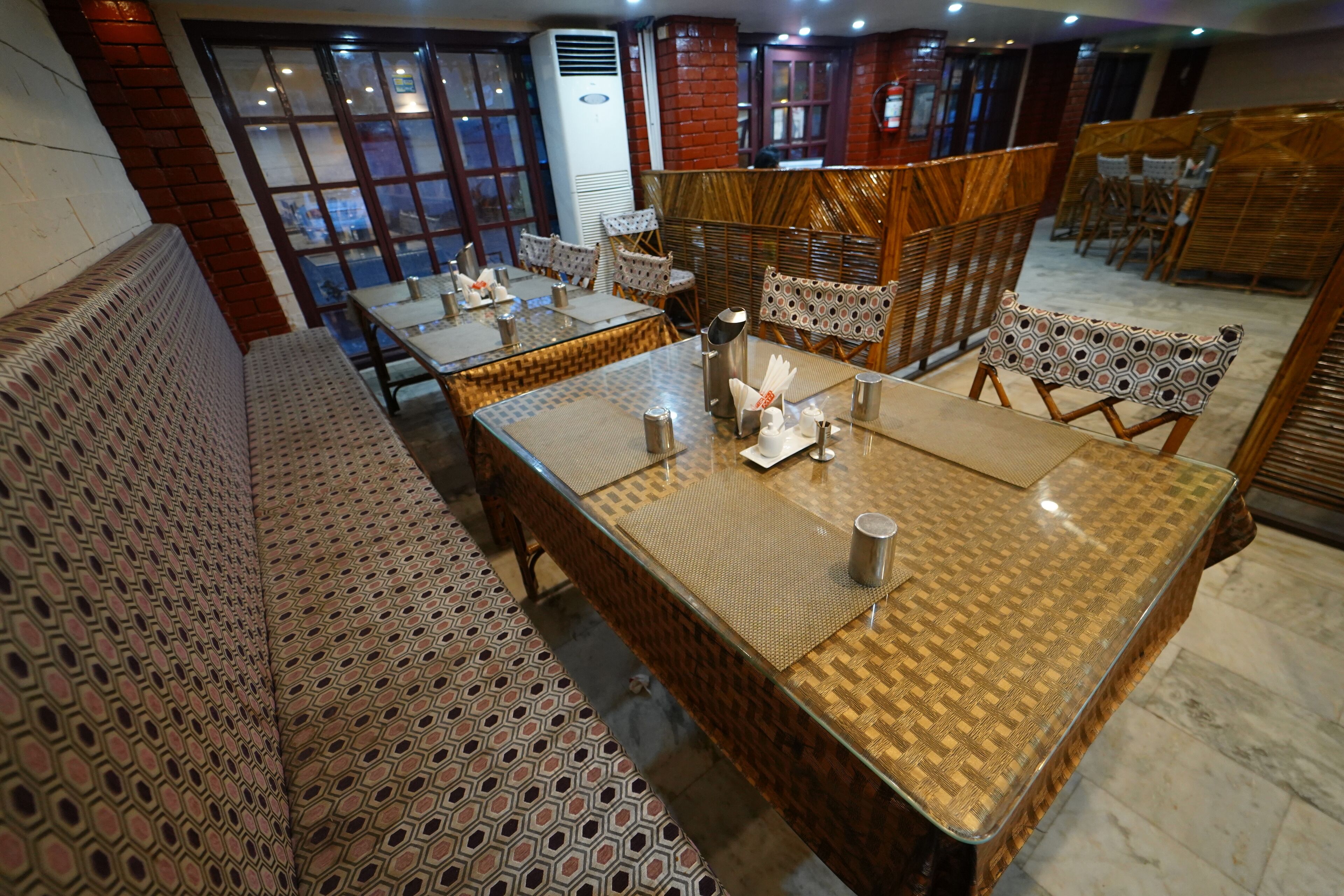 Um restaurante com um balcão comprido, assentos padronizados e vista através de grandes janelas.