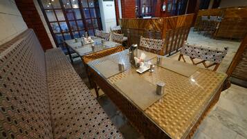 Um restaurante com um balcão comprido, assentos padronizados e vista através de grandes janelas.