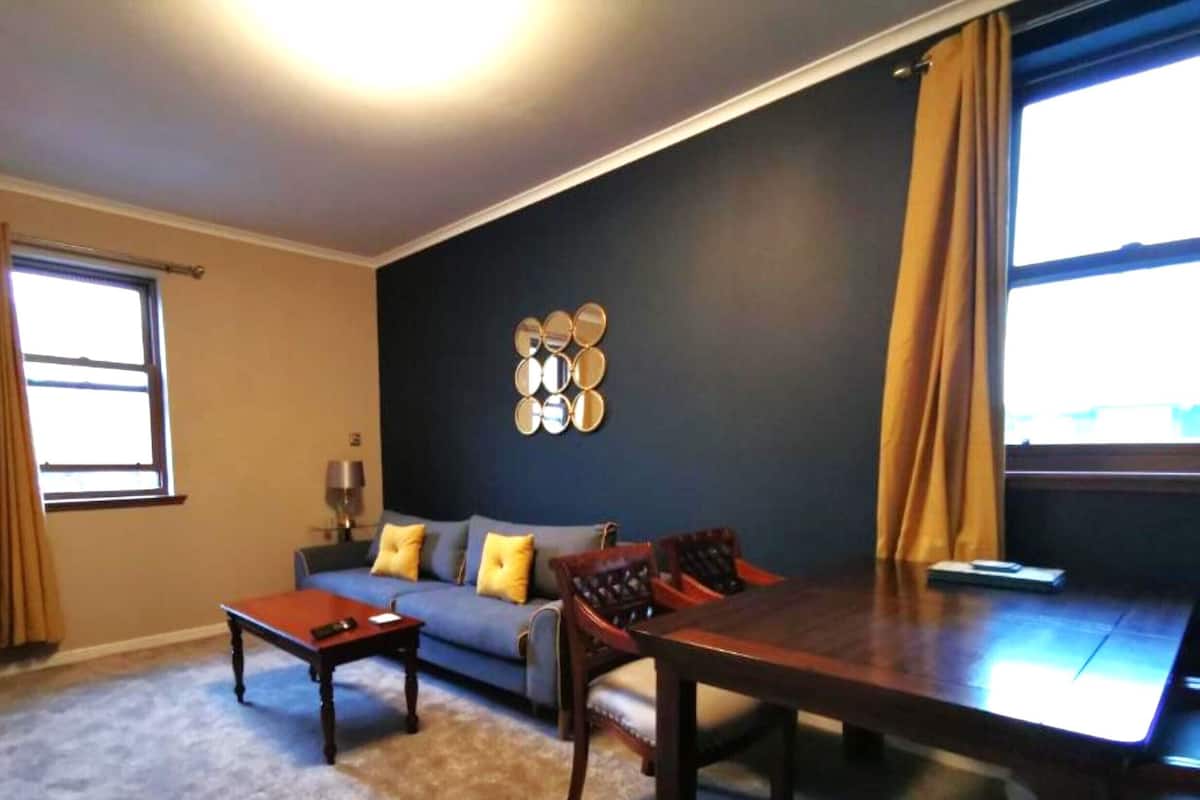 Uma sala de estar com sofá, mesa de centro e mesa de jantar.