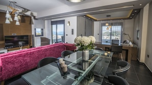 Uma sala de estar moderna com uma mesa de jantar de vidro, um sofá rosa e vista para a cidade.