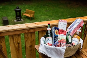 Um deck de madeira com uma cesta contendo diversos alimentos e garrafas de cerveja Bismarck.