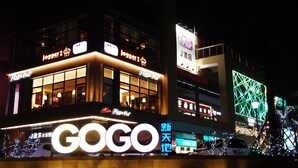 Um edifício com placas iluminadas para 'Pizza Hut' e 'GOGO'.