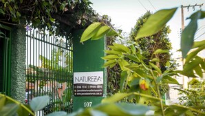 Um portão verde com uma placa indicando 'Natureza' e o número 107.