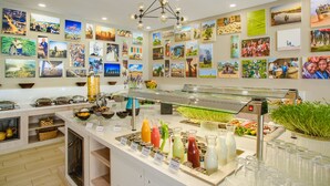 Uma área de buffet com diversas opções de comida e uma parede decorada com fotografias.