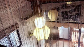 Quarto com teto de madeira, luminárias pendentes e uma janela grande.
