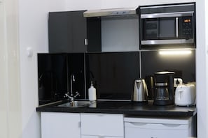 Um frigorífico/congelador grande, um micro-ondas, uma placa de cozinha