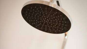 Chuveiro com design circular e perfurado.